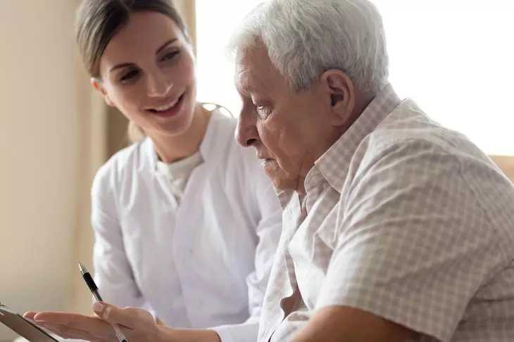 Senior vyplňování lékařské papírování s pečovatelem