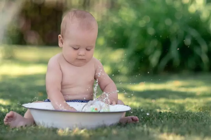 Baby boartet mei wetter yn kom